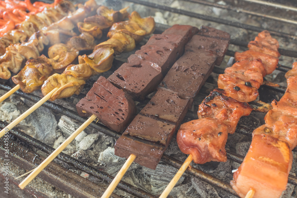 Various strange and exotic Philippine street foods on a charcoal grill ...