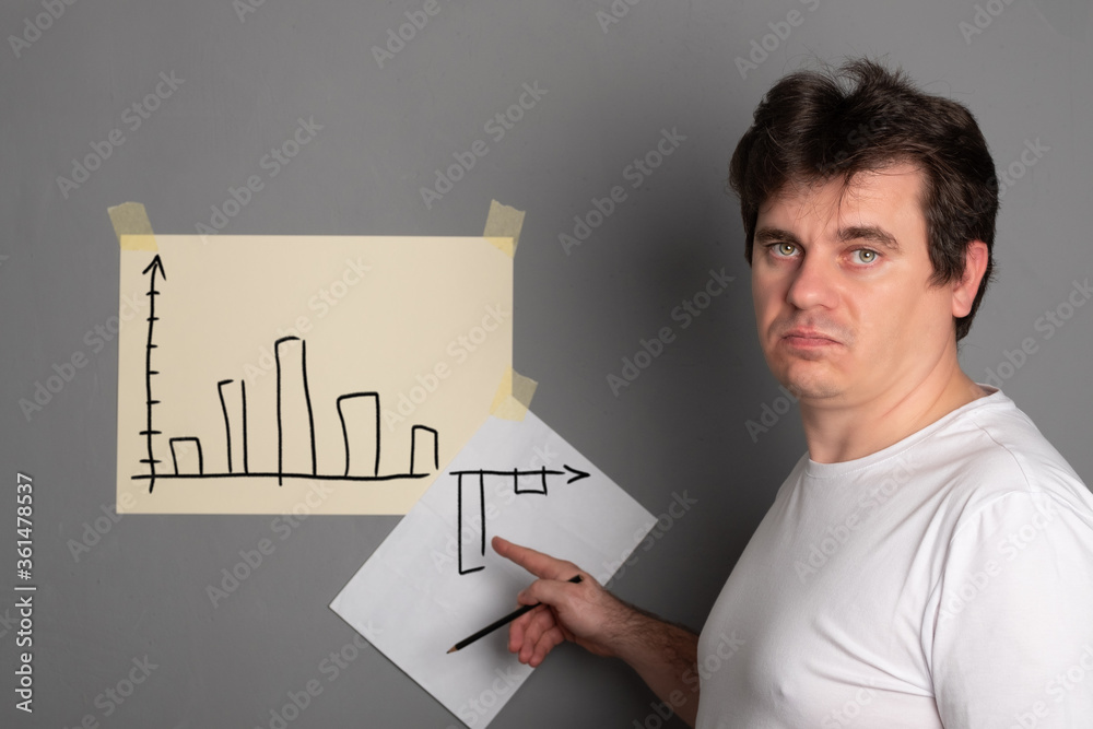 Sad man draws a graph with a drop down. Schedule of economic decline ...