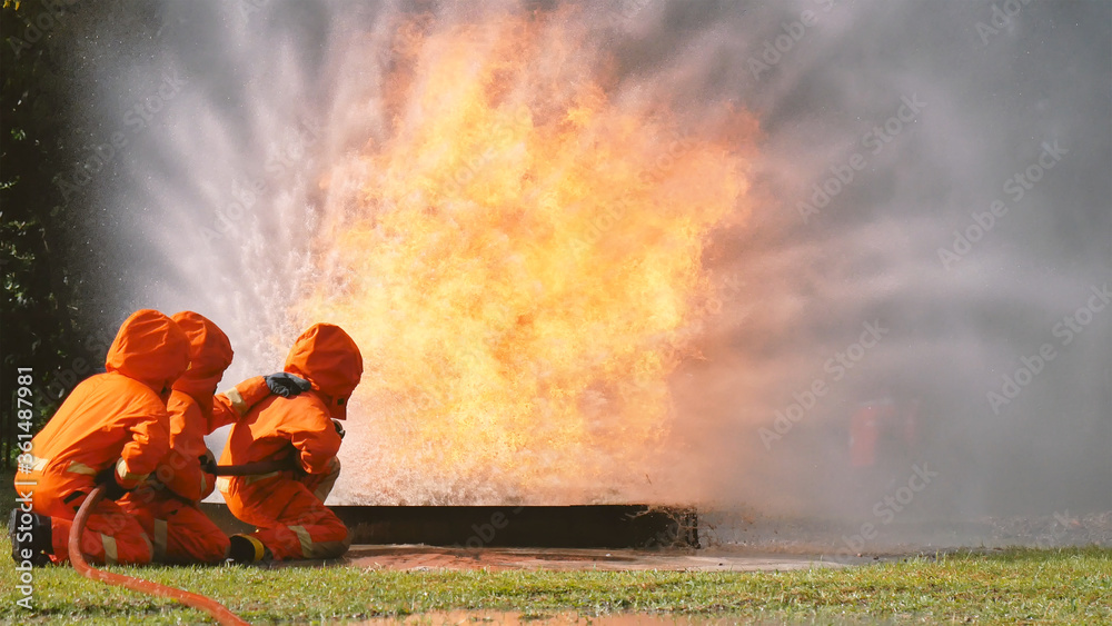 Firefighter fighting with flame using fire hose chemical water foam ...