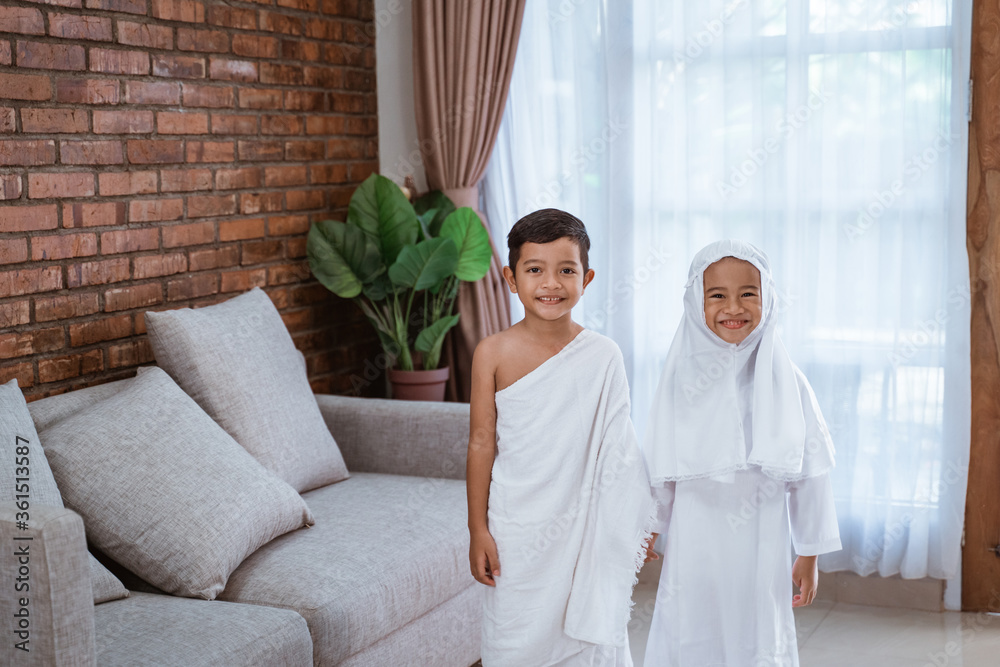 cute little kid wearing muslim ihram clothes and dress. hajj and umrah ...