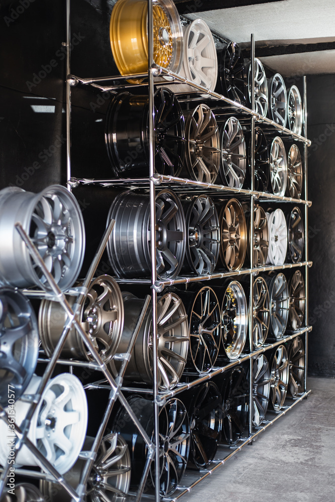 wall of alloy wheels in the store. Auto repair shop background. Auto ...