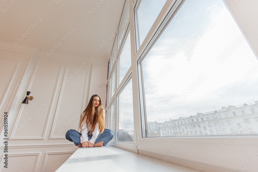 beautiful girl sitting on the window and smiling Stock Photo | Adobe Stock