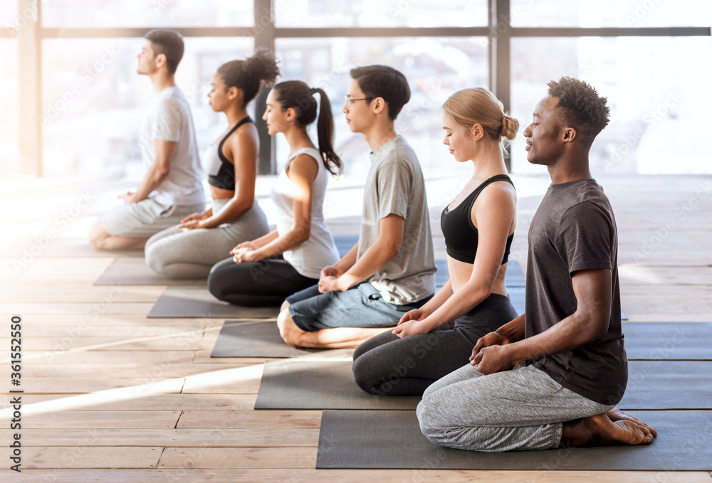 Wellness Concept. Young sporty people in yoga class making meditation ...