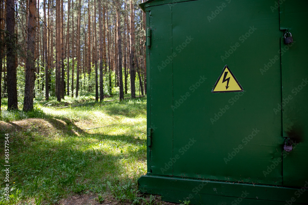 Locked electric panel with attention sign on the grey wall of ...