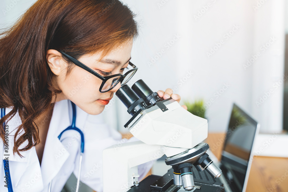 Medical health clinic beautiful Asian doctor using microscope examining ...