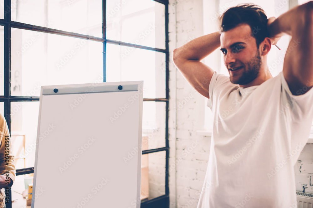 Handsome male student standing near blank board preparing for ...