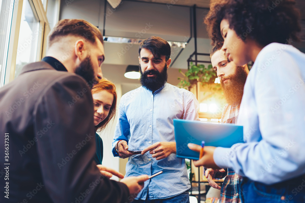 Young skilled architects brainstorming during informal meeting creating ...