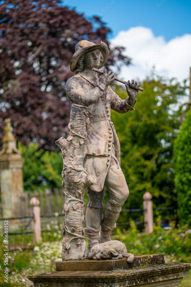 statue of shepherd young boy playing a flute with dog at his feet Stock ...