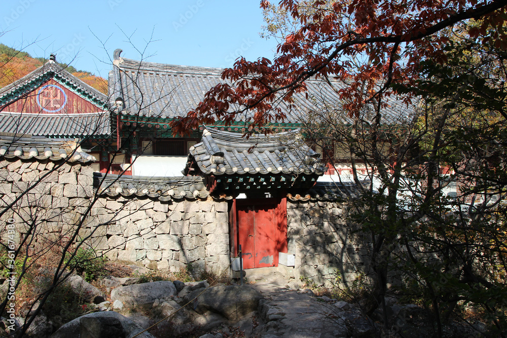 Korean traditional architecture of red door with autumn surrounding at ...