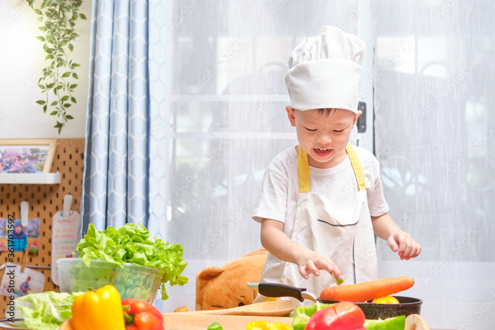Cute happy smiling Asian little boy child wearing chef hat and apron ...