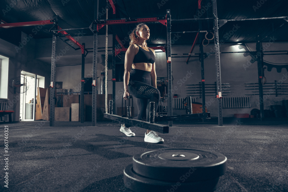 Beautiful young sporty woman workout in gym. Caucasian female trainer ...