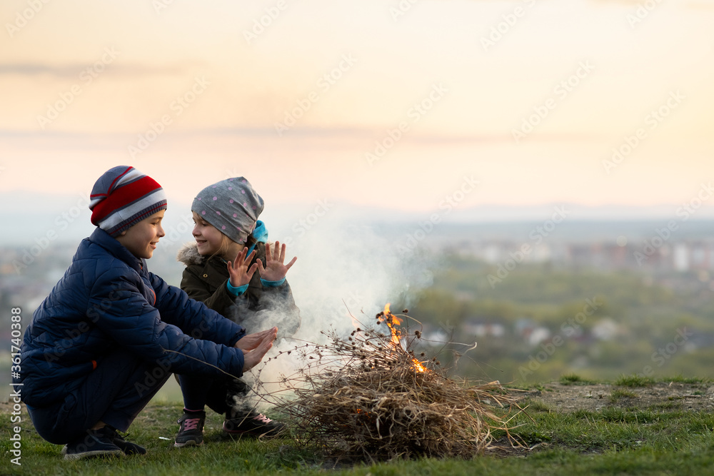Two children playing with fire outdoors in cold weather. Stock Photo ...