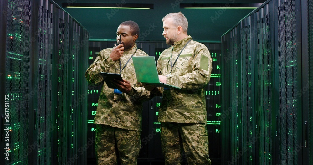 Multiethnic male army officers with tablet device and laptop computer ...