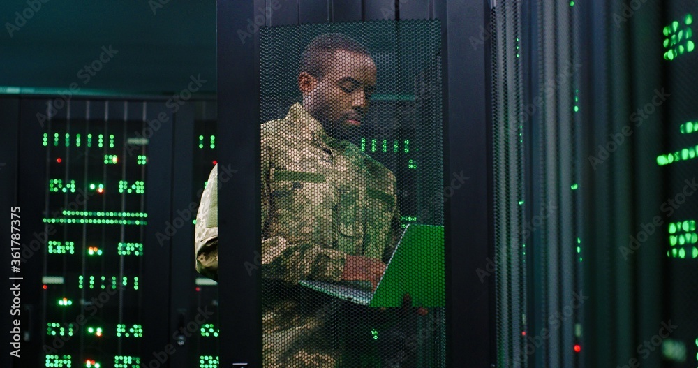 African Americam army man in camouflage costume opening server and ...