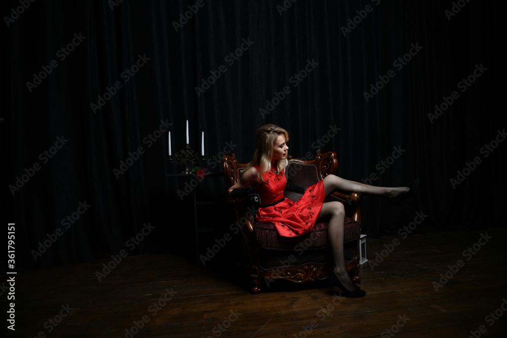 beautiful girl in a red dress posing in a chair in a waiting pose Stock ...