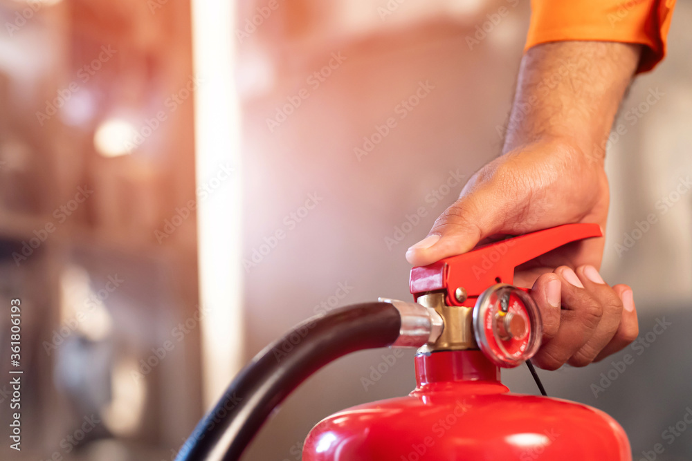 hand presses the trigger fire extinguisher available in fire ...