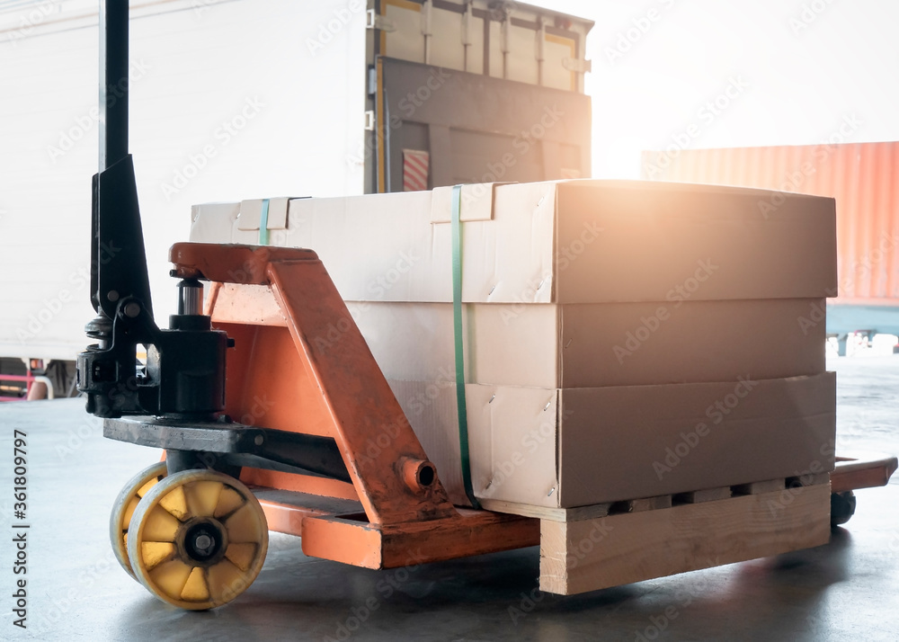 Hand pallet truck with package boxes on pallet waiting for load into a ...