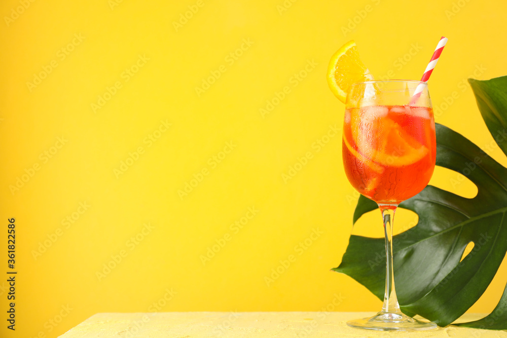 Aperol spritz cocktail and palm leaf on yellow background. Summer drink ...
