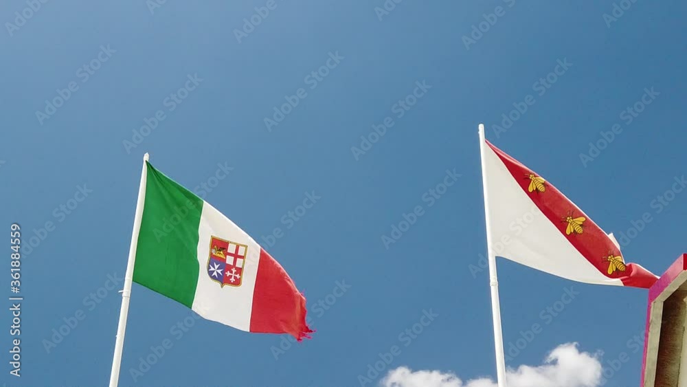 SLOW MOTION: Italian flag and Elba island flag waving on blue sky ...