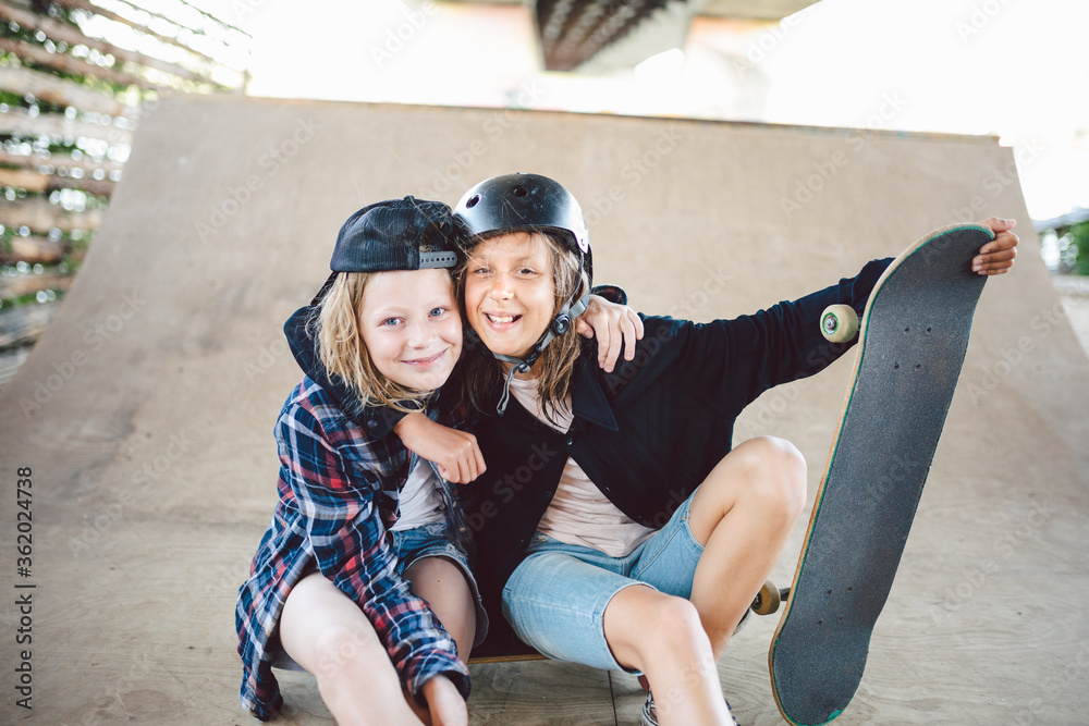Group of friends athletes skateboarders posing together in a skate park ...