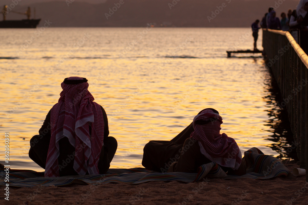Poster Two Arabic men wearing keffiyeh, agal and thobe are seen on the ...