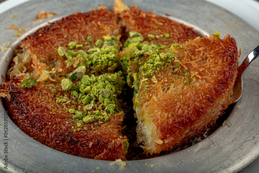 Turkish dessert kunefe, kunafa, kadayif with pistachio powder and ...