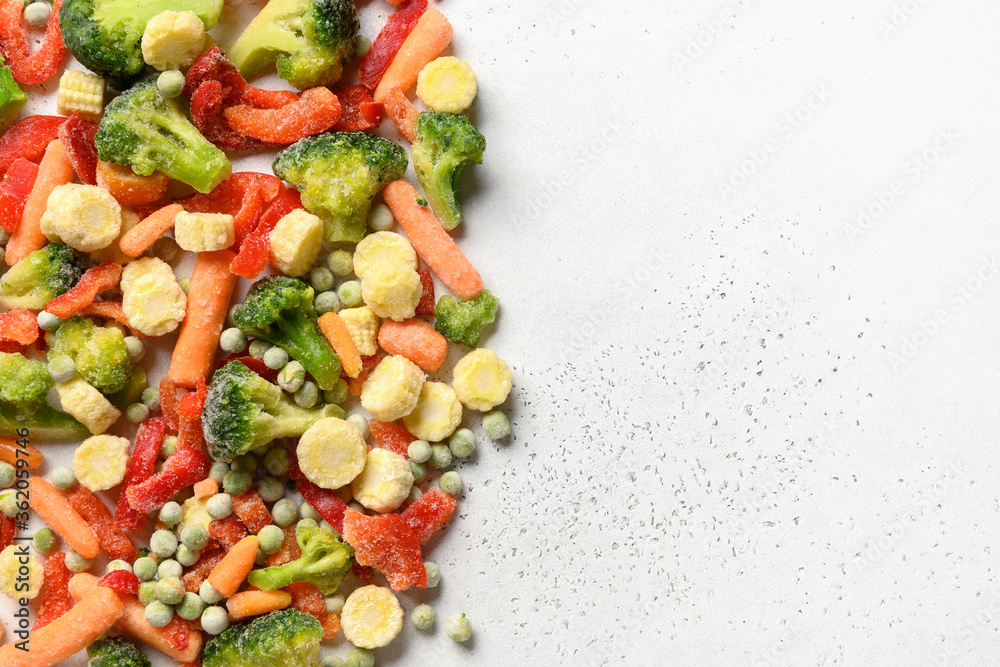 Border of frozen food vegetables on white background. Space for text ...