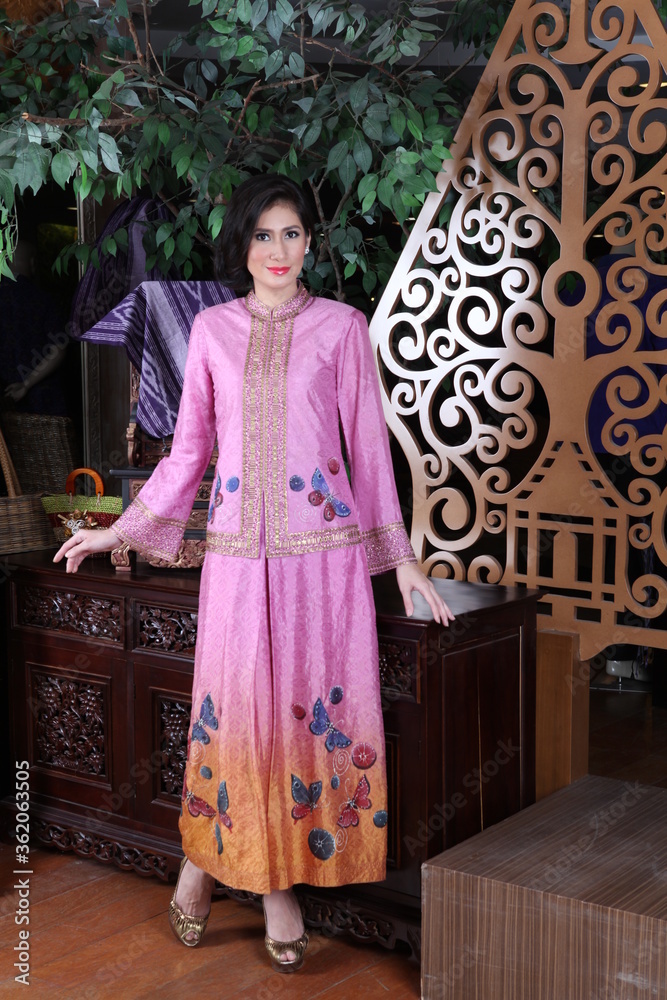 Beautiful woman wearing an elegant batik dress, Batik is a fabric that ...