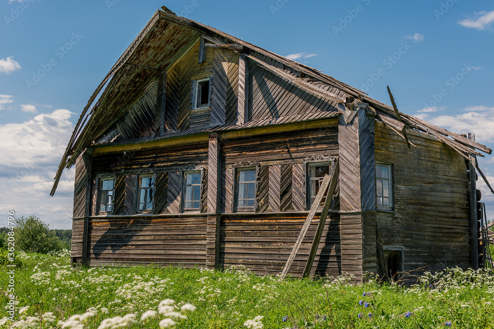 An old, abandoned, crumbling wooden house. One-story large house ...