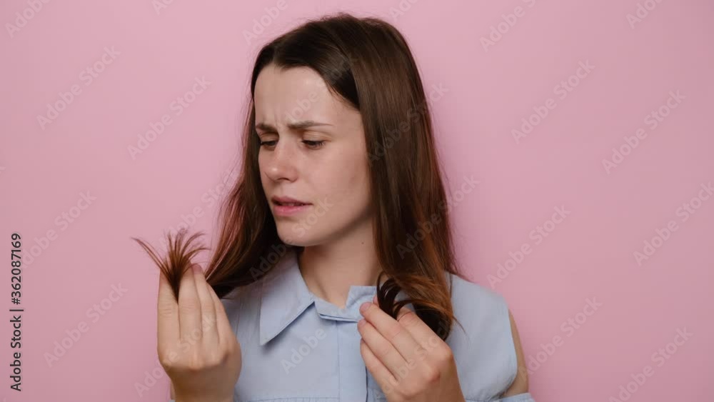 Sad depressed young woman touching damaged hair, worrying about hair ...