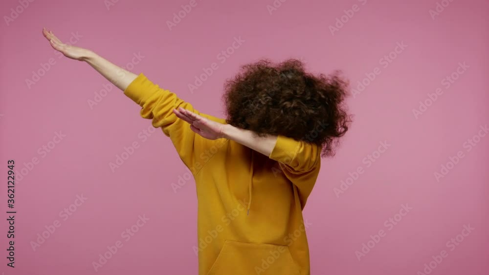 Trendy girl afro hairstyle in hoodie performing dab dance with serious ...