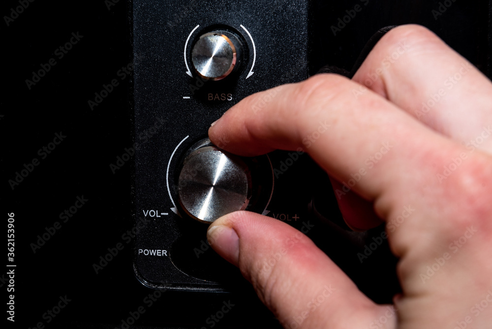 Hand adjusting volume control of subwoofer audio amplifier. Stock Photo ...