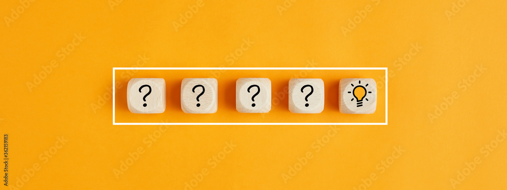 The process of problem solving or idea formation. Question mark and light bulb icons on wooden ...