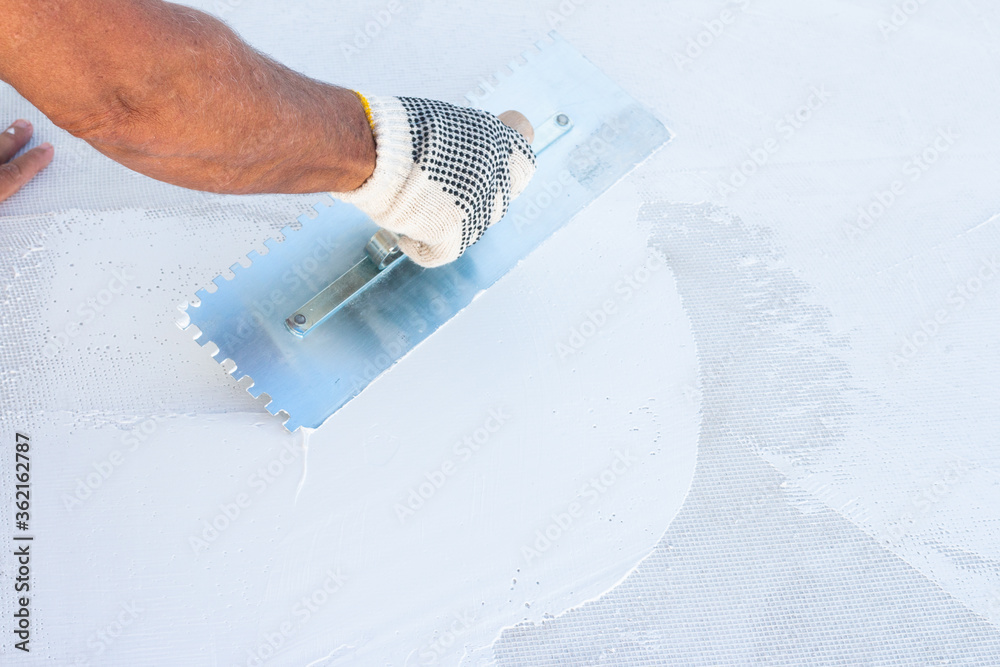 Builder using plastering tool for finishing wall and floor. Stock Photo ...