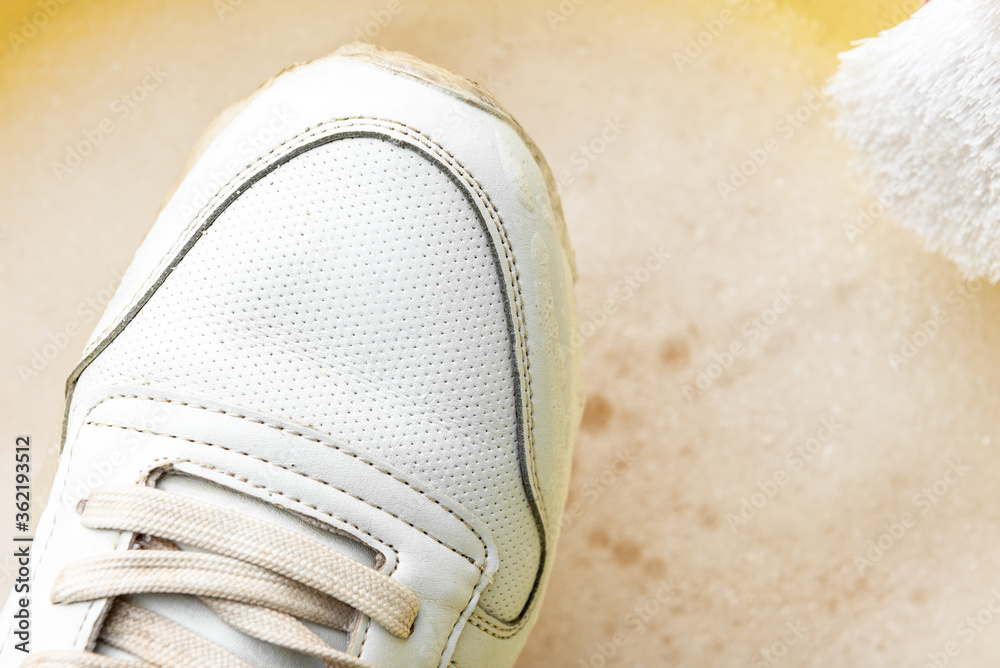 Sneakers in a wash basin with soapy water. Washing the dirty sneakers ...