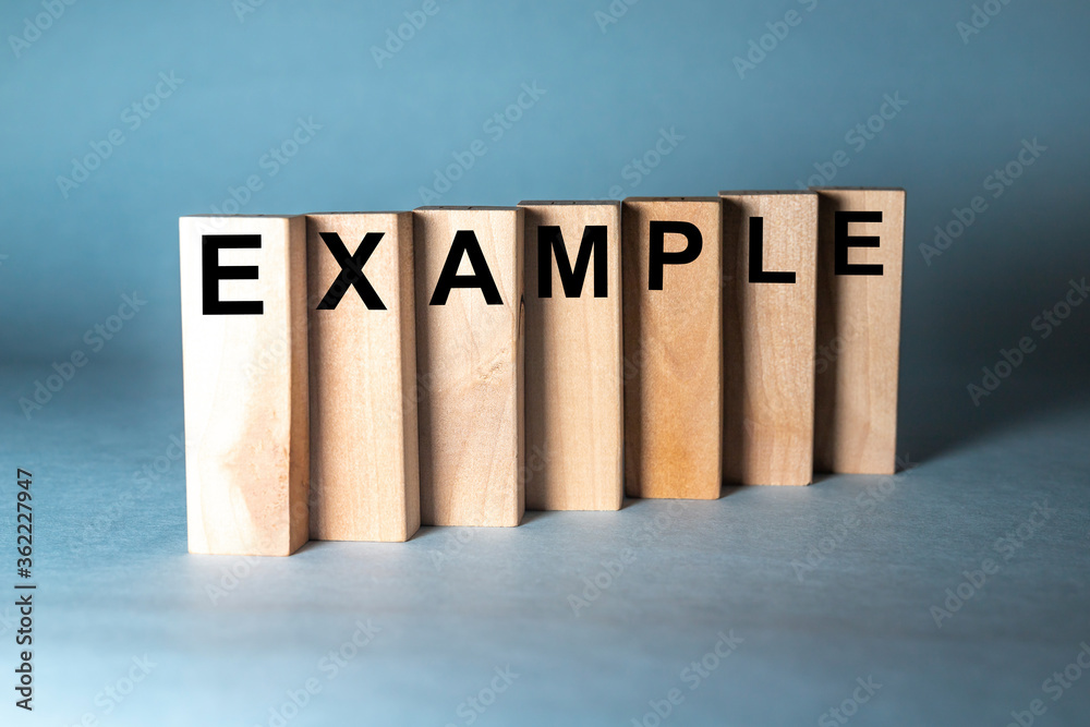 EXAMPLE word written on wooden blocks on blue grey background Stock ...