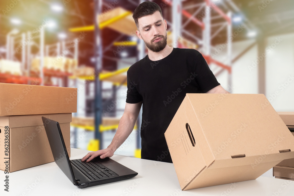 The storekeeper looks at the markings on the cardboard box. Working in ...