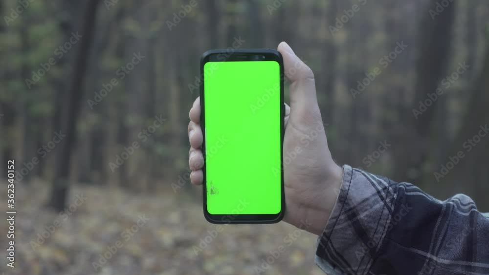 Concept shot of crashed green screen hand of young man holding chroma ...