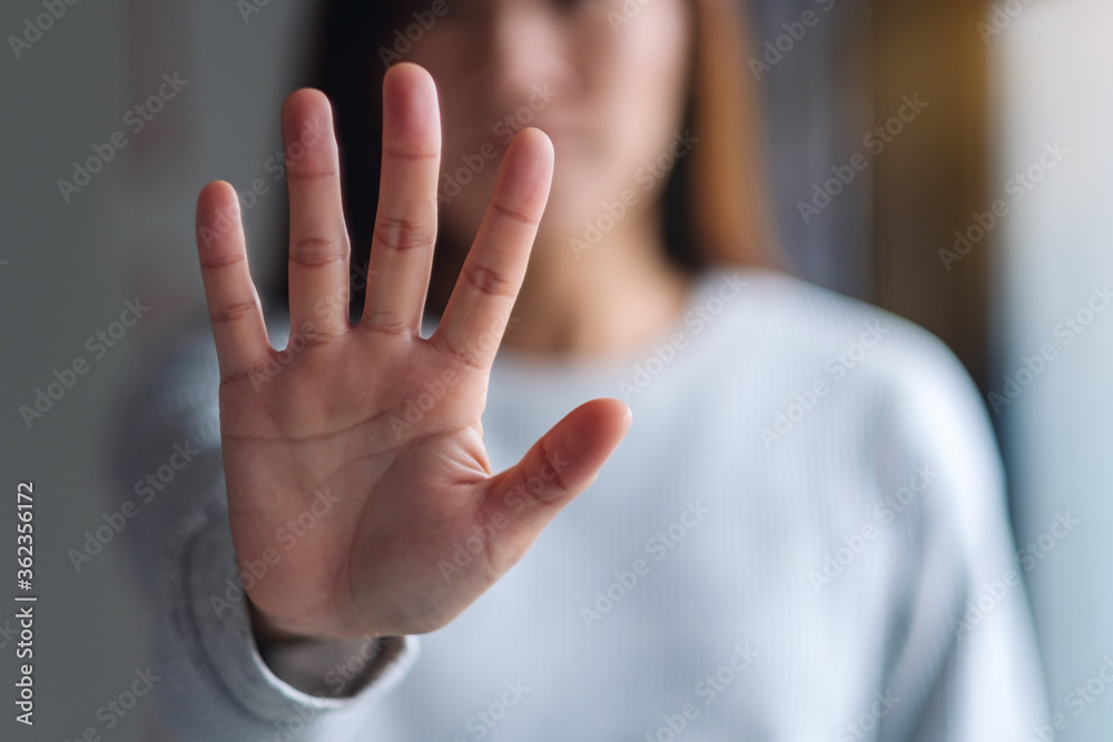 Closeup image of a woman outstretched hand and showing stop hand sign ...
