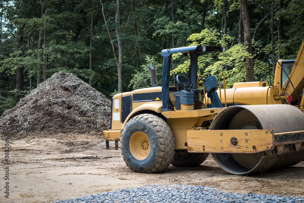Tractor roller / vibratory soil compactor in front of pile of shredded ...