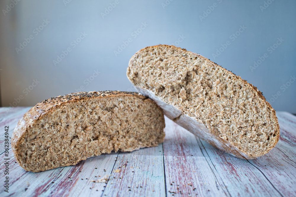 Wholemeal bread with chia seeds. Round bread cut in half with white ...