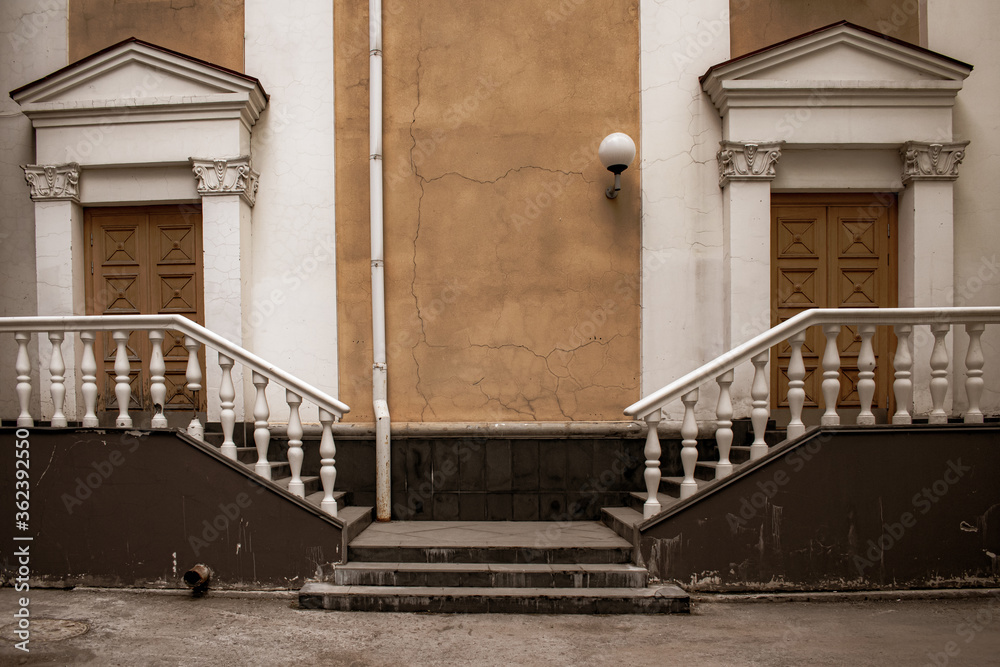 Courtyard of an old architectural building, two doors with stairs on ...