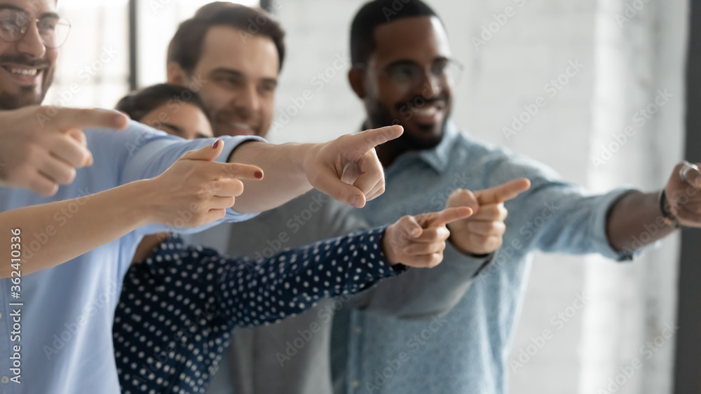 Group of happy multi ethnic people pointing finger aside standing ...