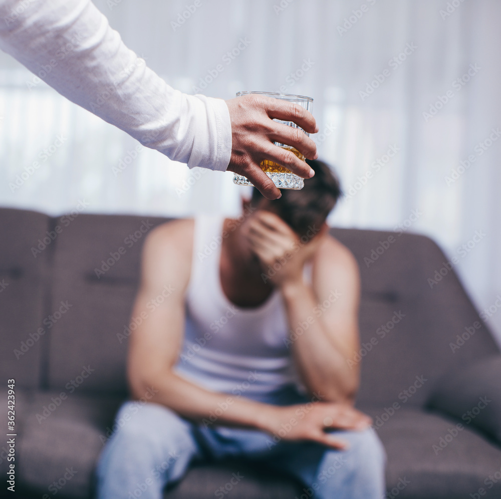 young messy and drunk alcohol addict man drinking whiskey glass at home ...