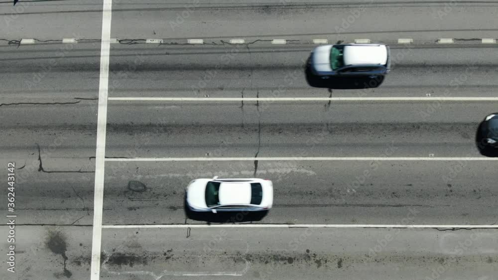 Three lanes of traffic on multilane highway, cars drive slowly on road ...