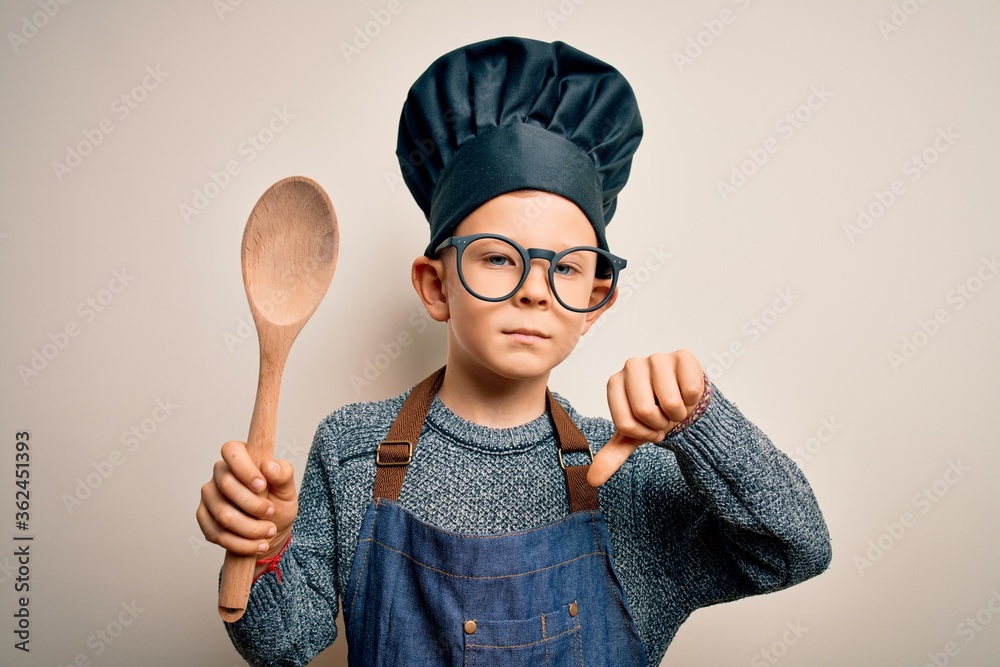 Young little caucasian cook kid wearing chef uniform and hat cooking ...