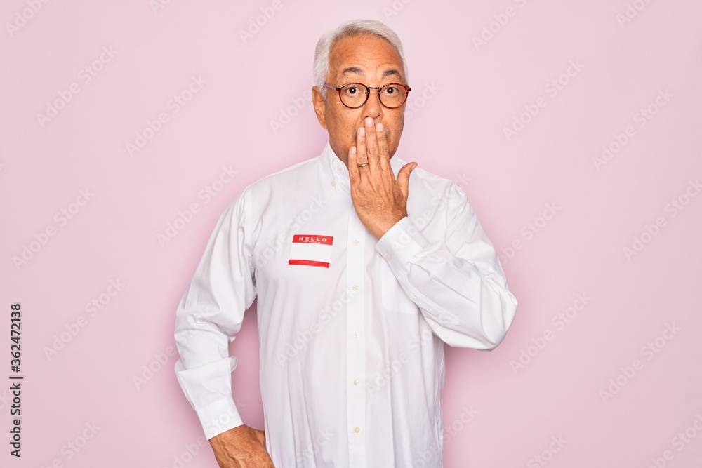 Middle age senior grey-haired man wearing hello my name is introduction ...