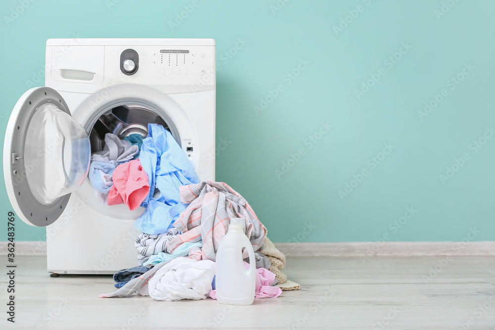 Washing machine with dirty clothes and detergent in home laundry room ...
