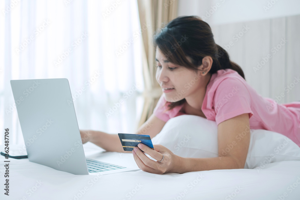 Happy woman holding credit card and using computer laptop for online ...