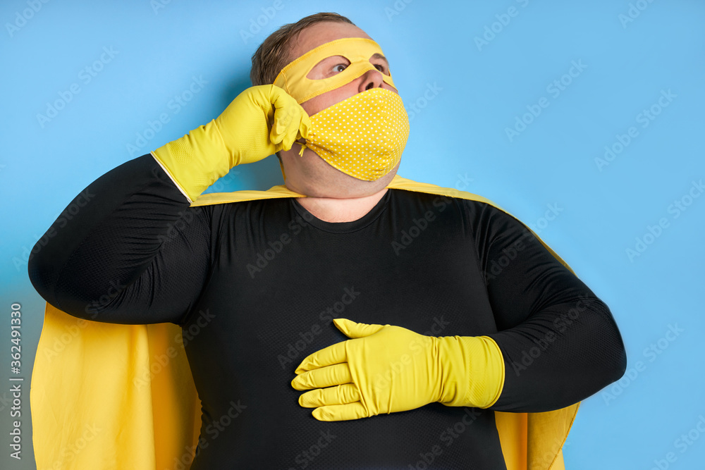 young caucasian fat cleaning man in costume of superhero and in mask ...